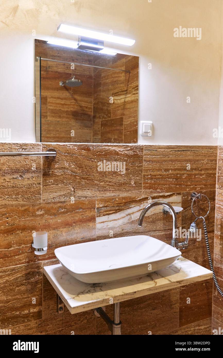 This modern bathroom features luxurious marble tiles, a sleek white ...