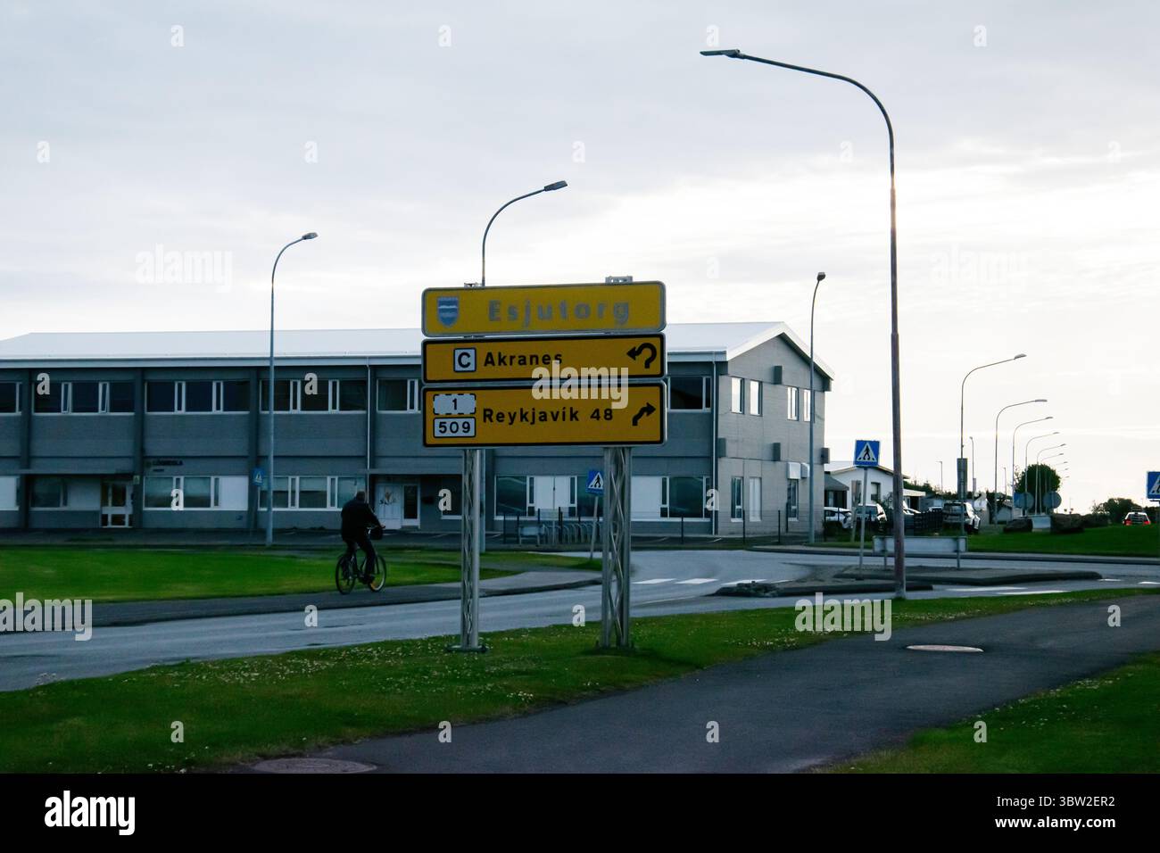 Street view with direction signs and a cyclist in Akranes, Iceland ...