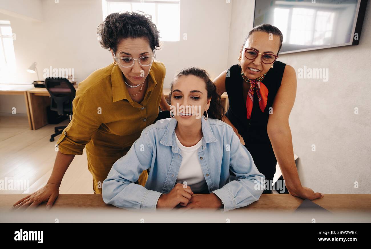 Three professional women engage in teamwork, collaborating on a project ...