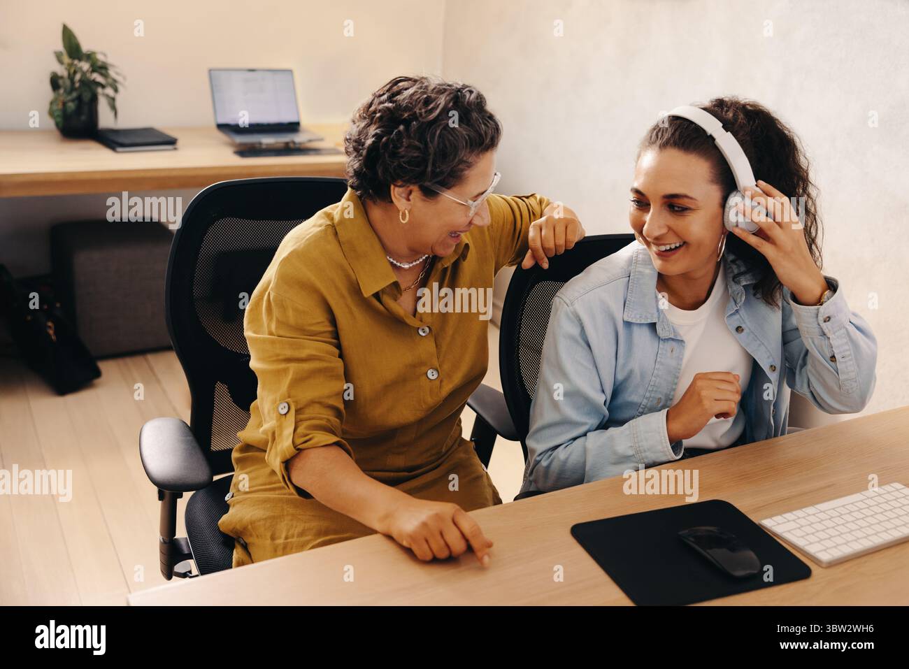 Friendly office scene featuring coworkers of different ages interacting ...