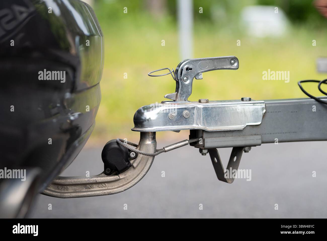 Trailer attached to a car. Hitch coupling locked to tow a small vehicle ...