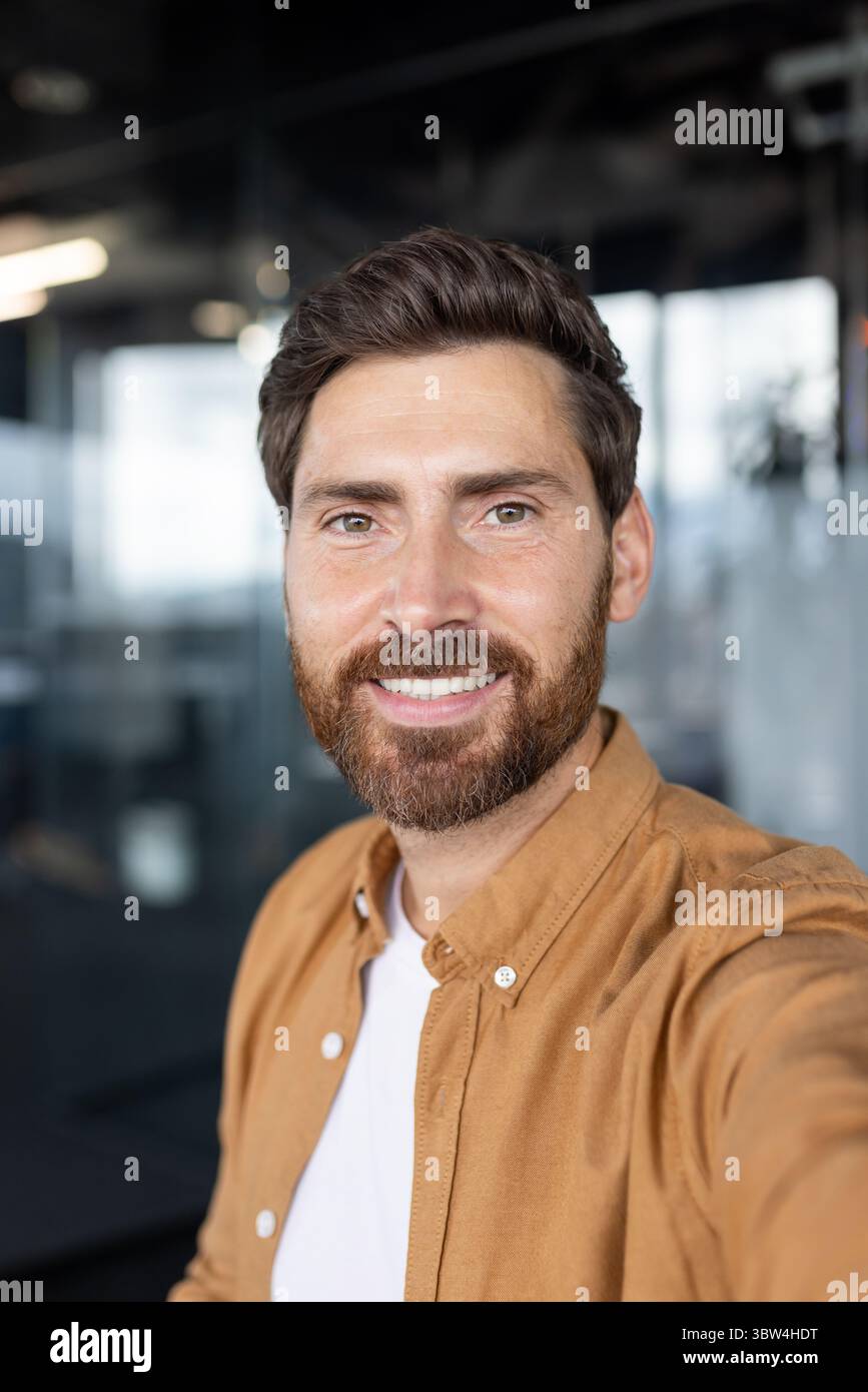 Young successful businessman looking into phone camera, using ...