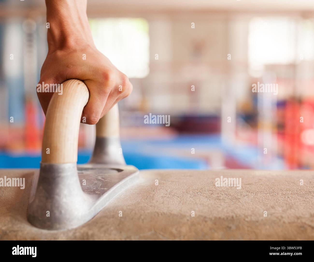 Hand of gymnast gripping handle of pommel horse in training hall Stock ...
