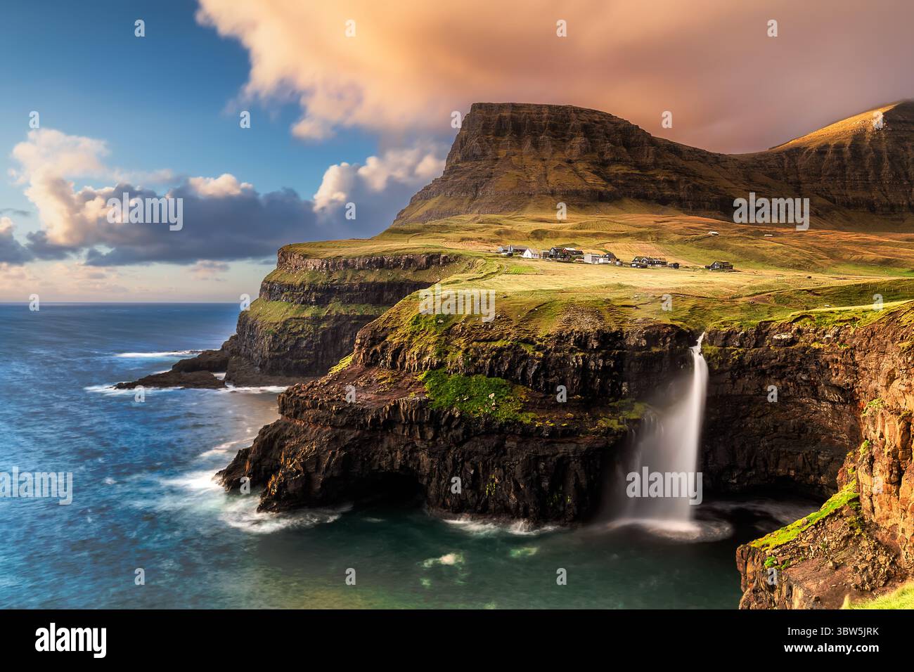 View of cascading waterfall plunges from a cliffside village into the ...