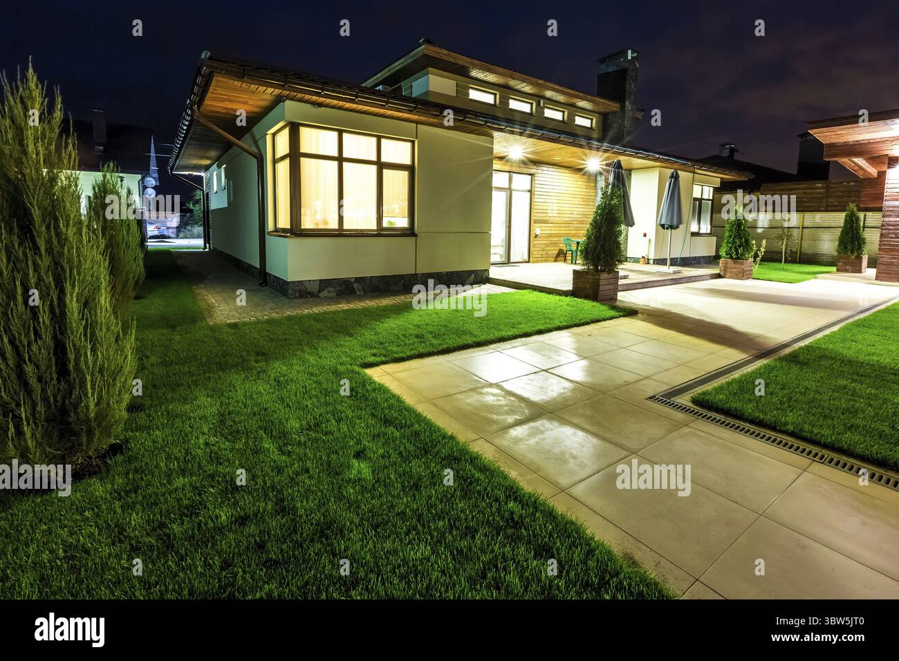 Detached luxury house at night - view from outside the rear courtyard ...