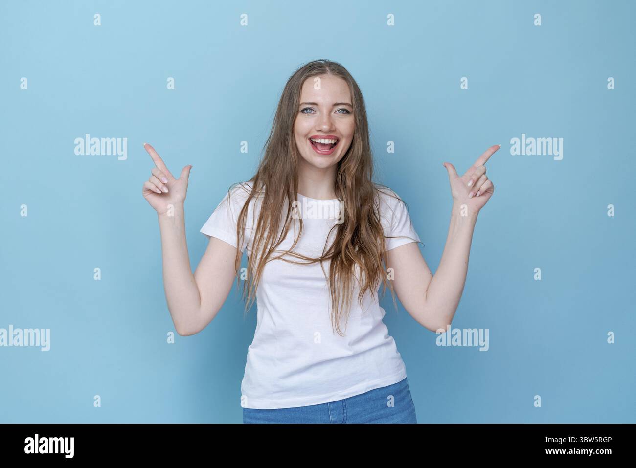 Hey look. Smiling beautiful female model pointing her fingers to an ...