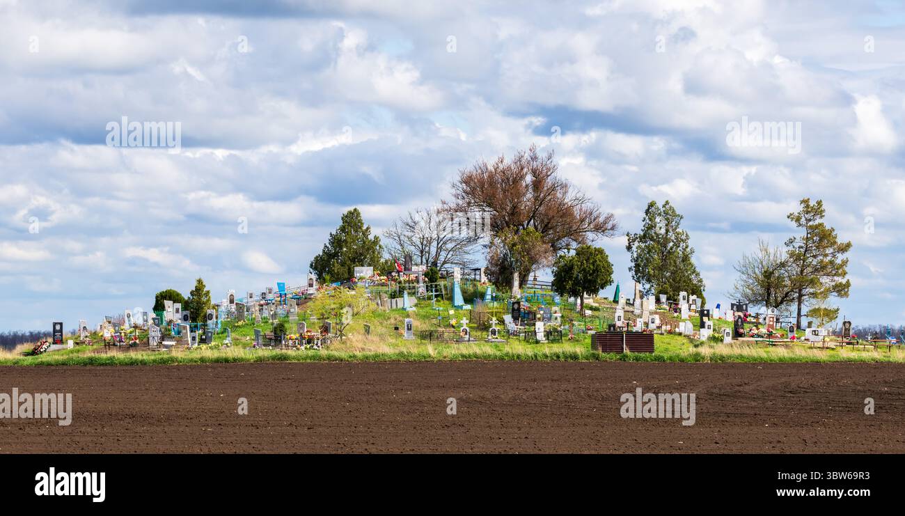 Novokorsunskaya, Russia - April 04, 2025: Cemetery on a mound among ...