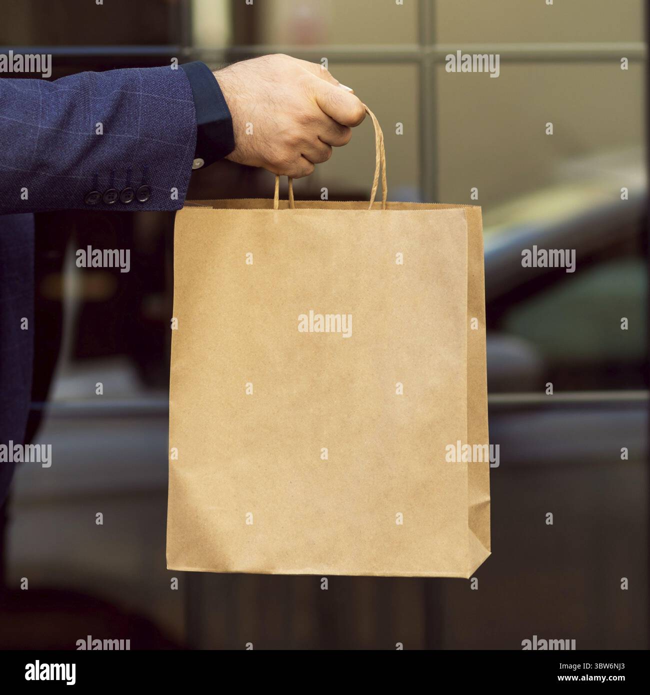 Man hand holding a paper bag outside. Using a paper bag to save ...