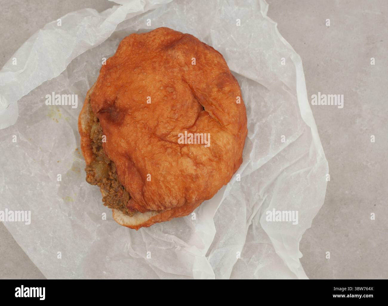 Traditional South African street food known as vetkoek with curry mince ...