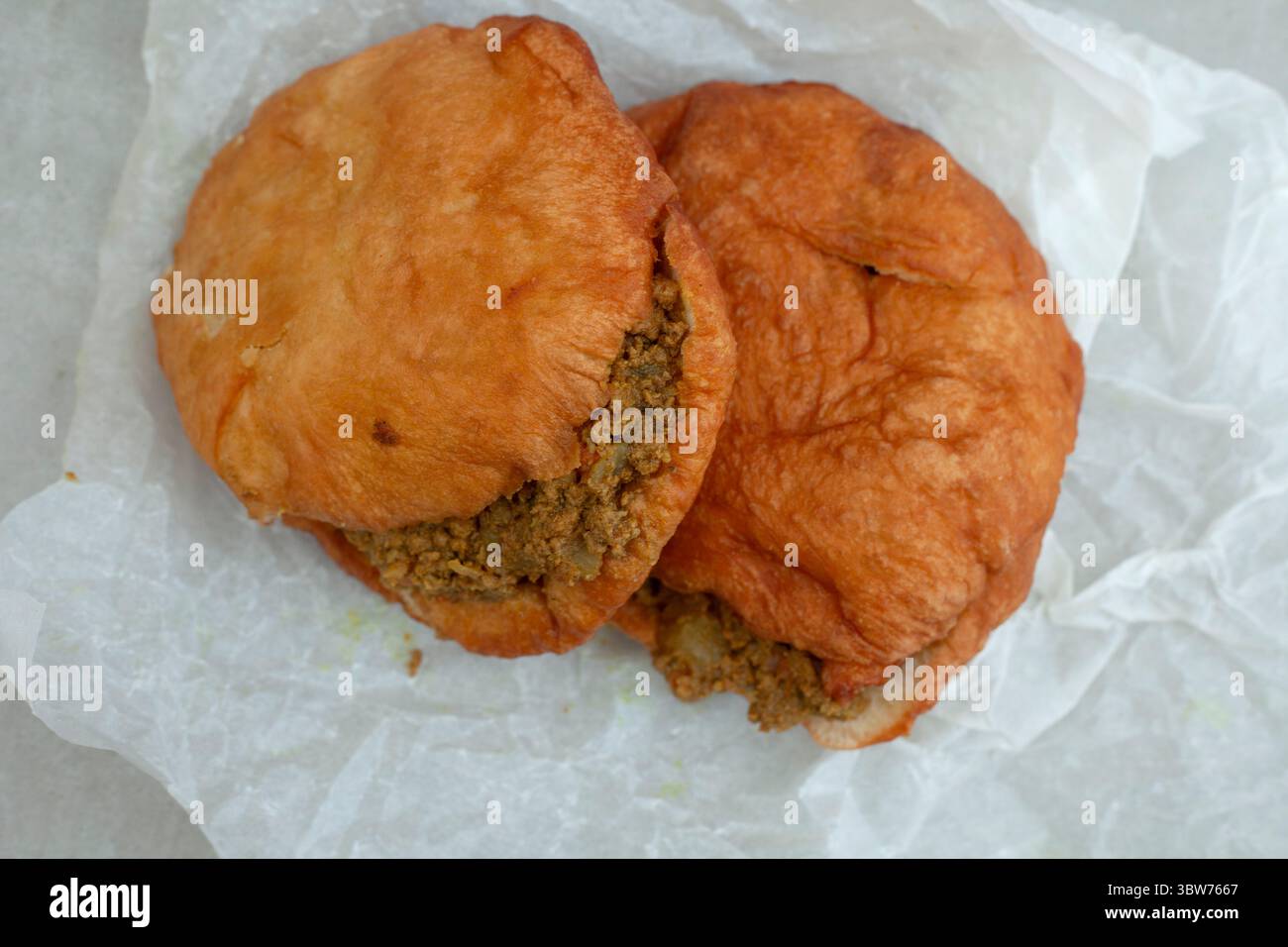 Traditional vetkoek with curry mince. top view of vetkoek on take away ...
