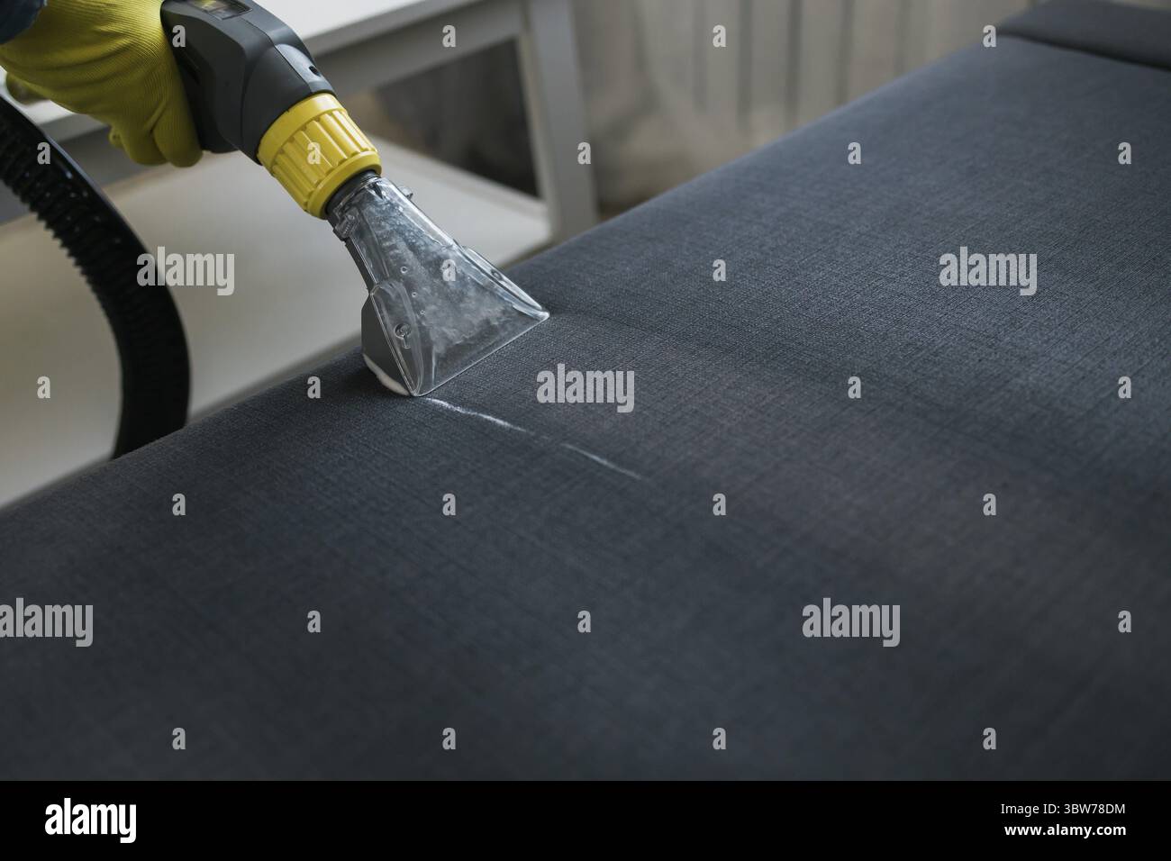 Man dry cleaner's employee hand in protective rubber glove cleaning ...