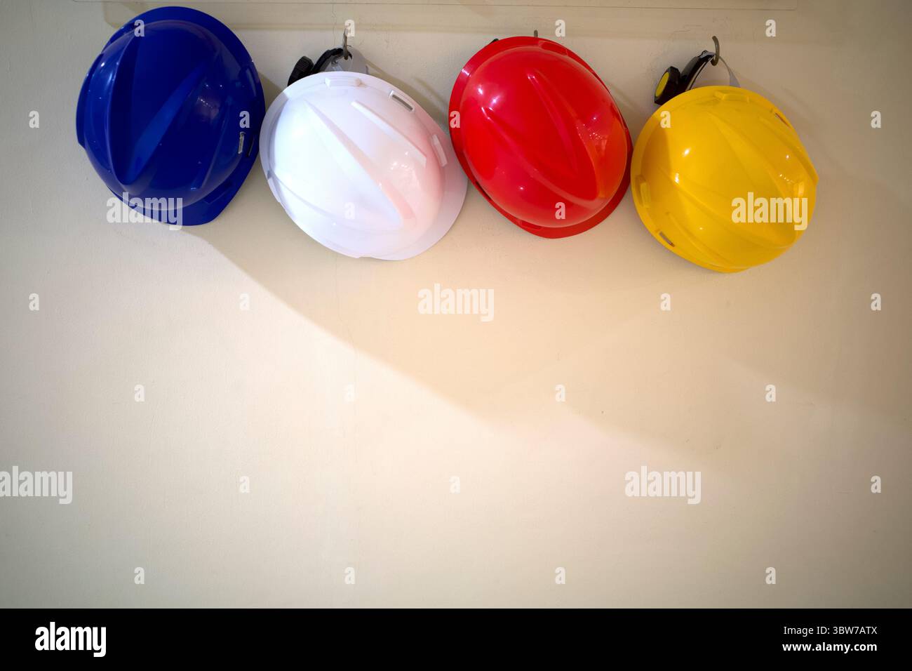 Four colorful safety helmets representing blue, white, red and yellow ...