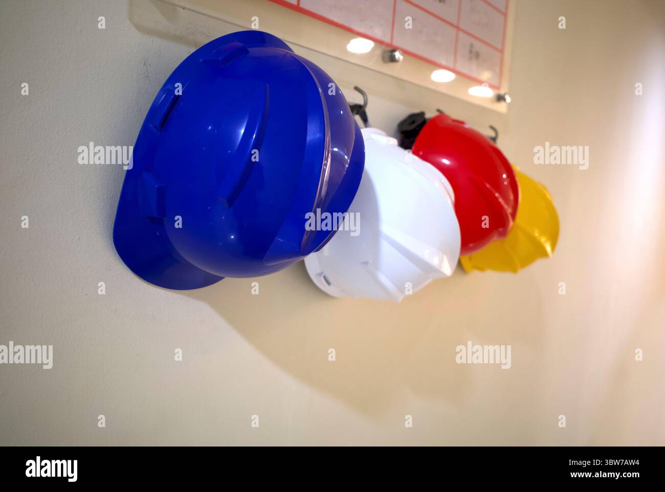 Four colorful safety helmets representing blue, white, red and yellow ...