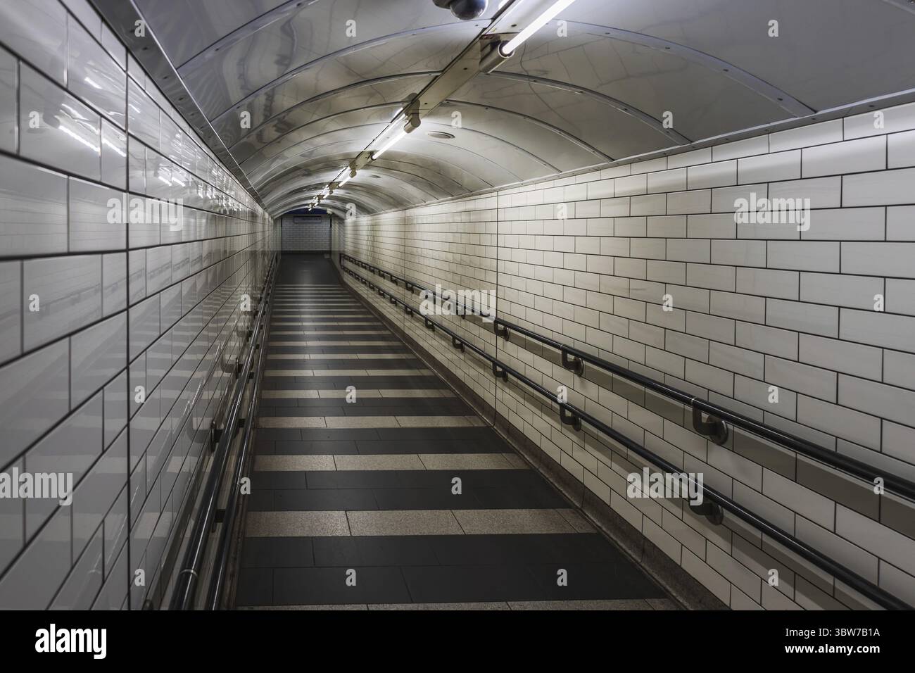 Empty tiled tunnel in the London Underground, featuring fluorescent ...