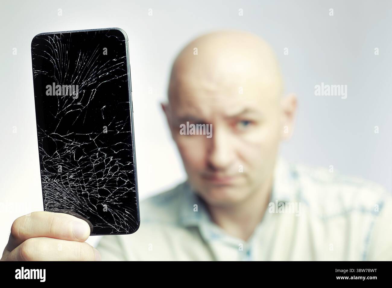 Phone With A broken screen close-up. A white man is holding a black ...