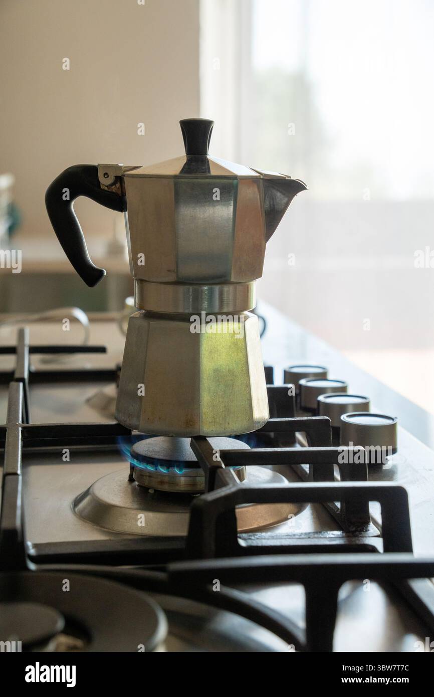 A classic italian moka pot brewing fresh espresso on a gas stove, with ...