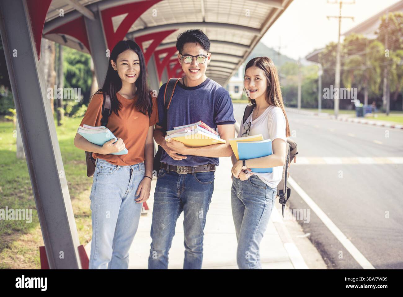 Three Asian young campus students enjoy tutoring and reading books ...