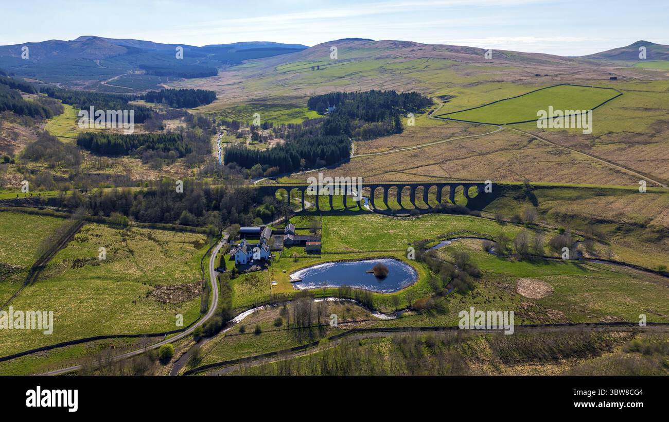 Aerial view of the graceful arches of a viaduct span a valley, a ribbon ...