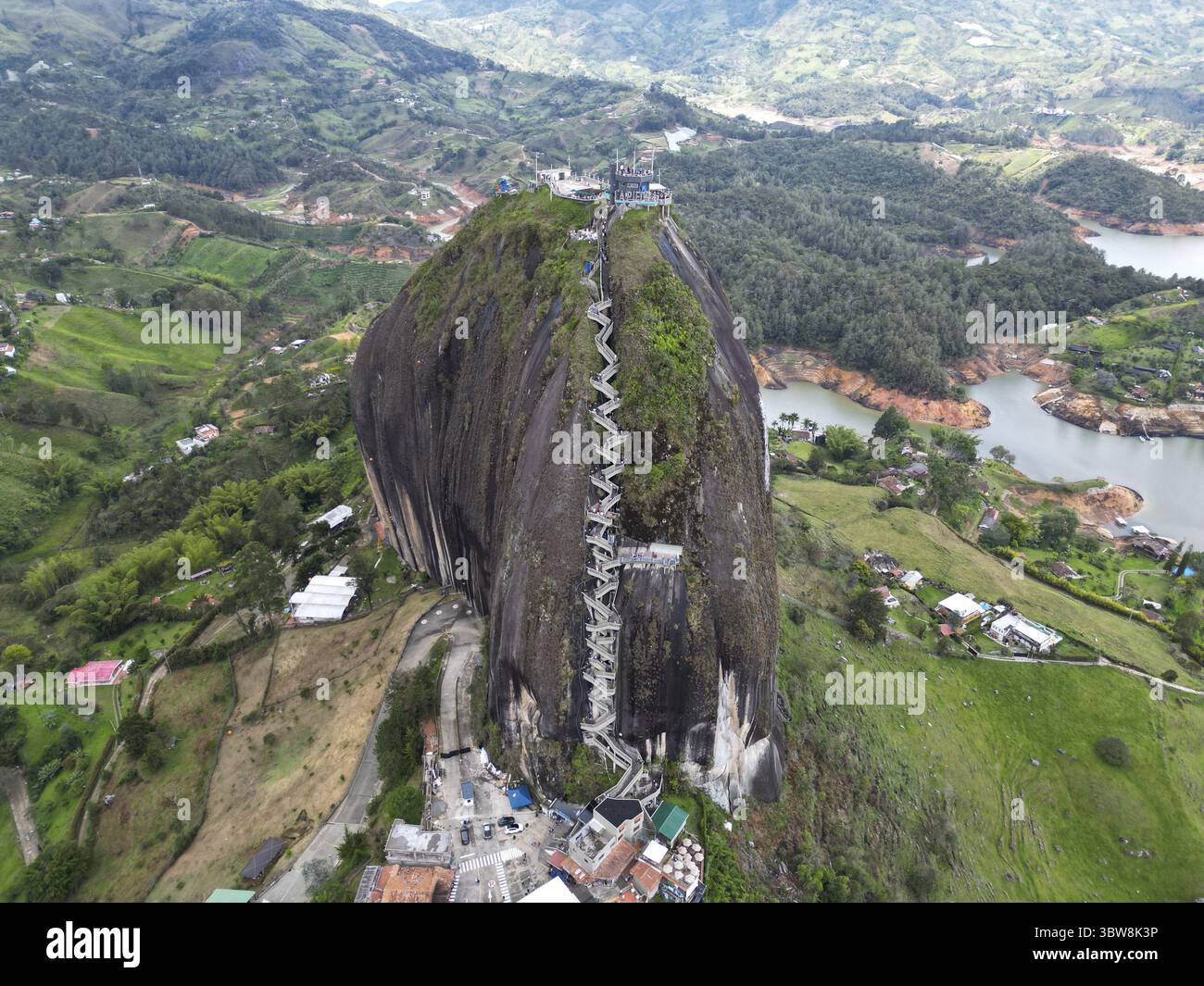 Aerial view of El Penol rock dramatically rising from lush green hills ...