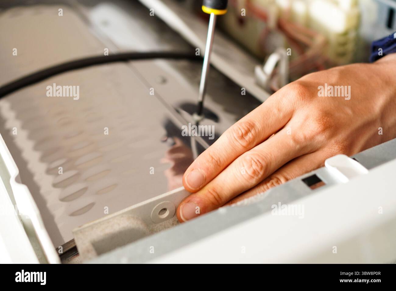 An appliance engineer repairing a broken washing machine Stock Photo ...