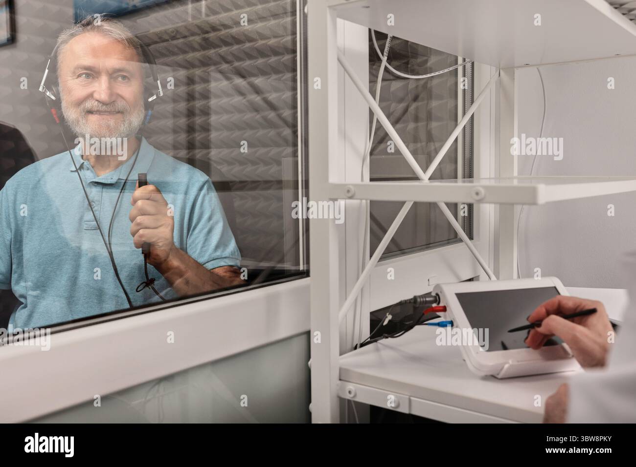 Elderly man getting a hearing test at audiology center. Audiometry ...