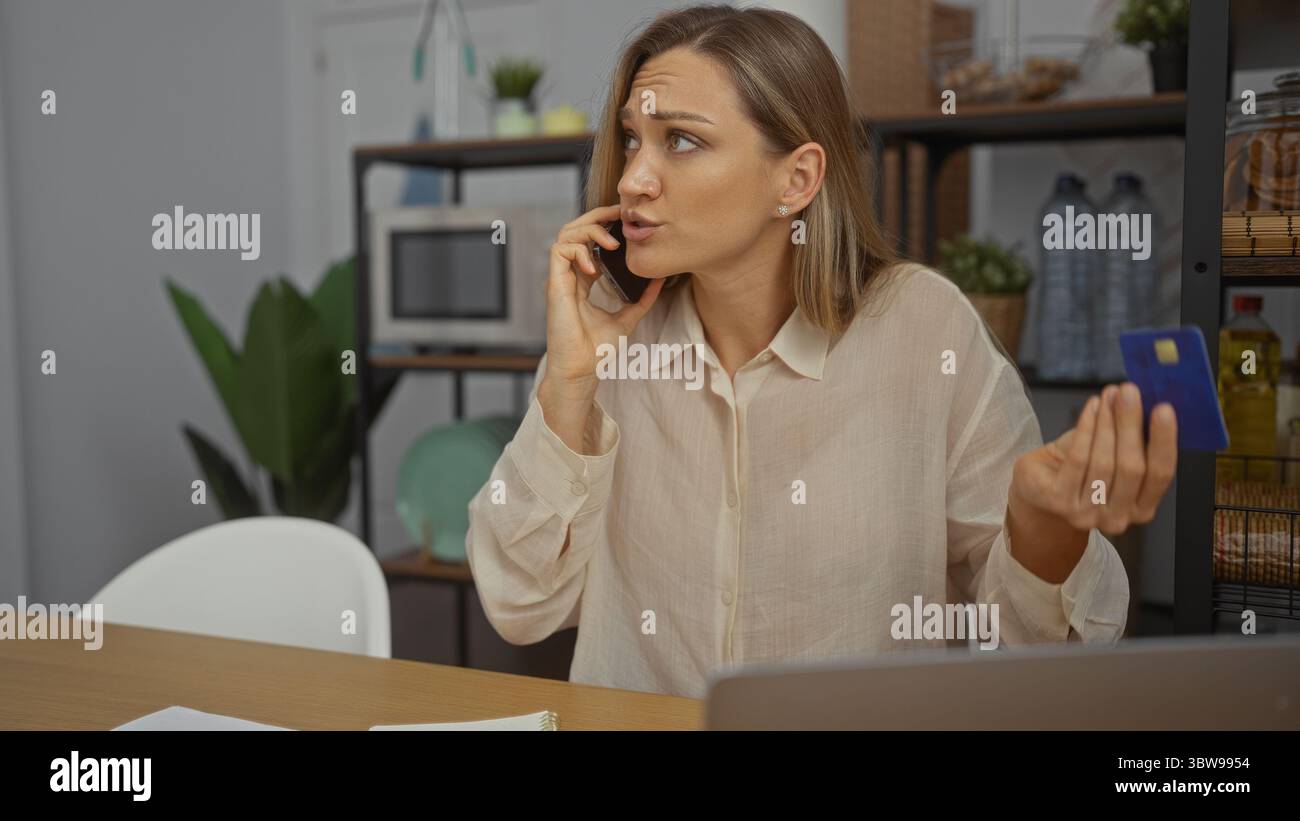 Woman talking on phone indoors holding credit card in office setting ...