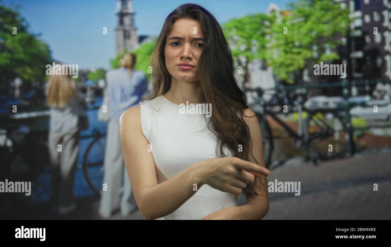 Woman points finger on busy city street at passing cyclist with visible ...