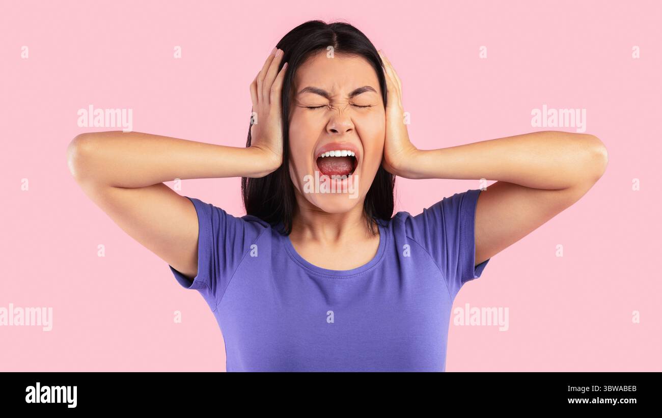 Angry asian woman covering her ears with hands and screaming Stock ...