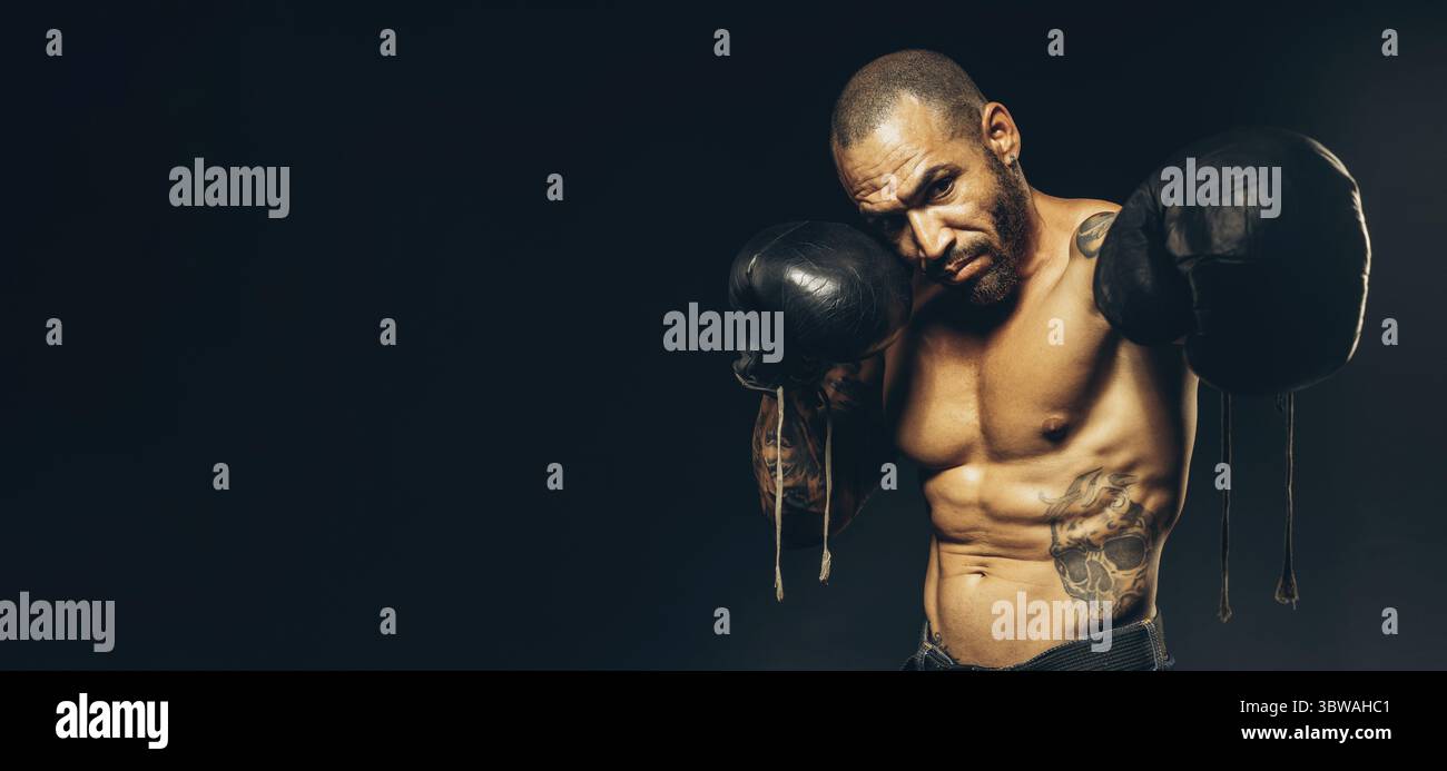 A boxer puncher with gloves strikes. The fighter is African American ...