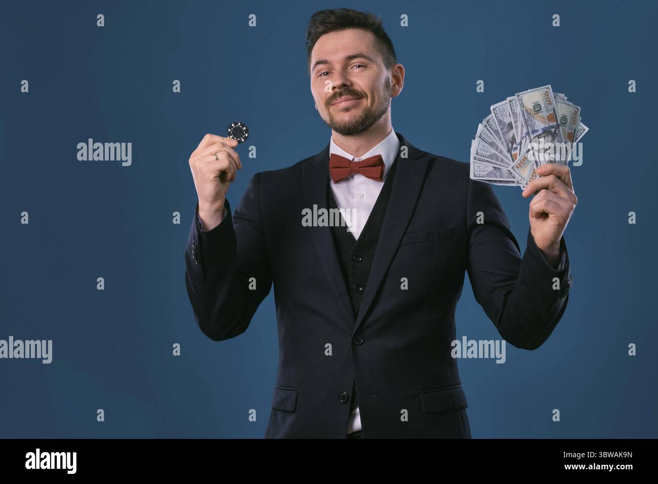 Elegant brunet male in black classic suit and red bow-tie smiling and ...