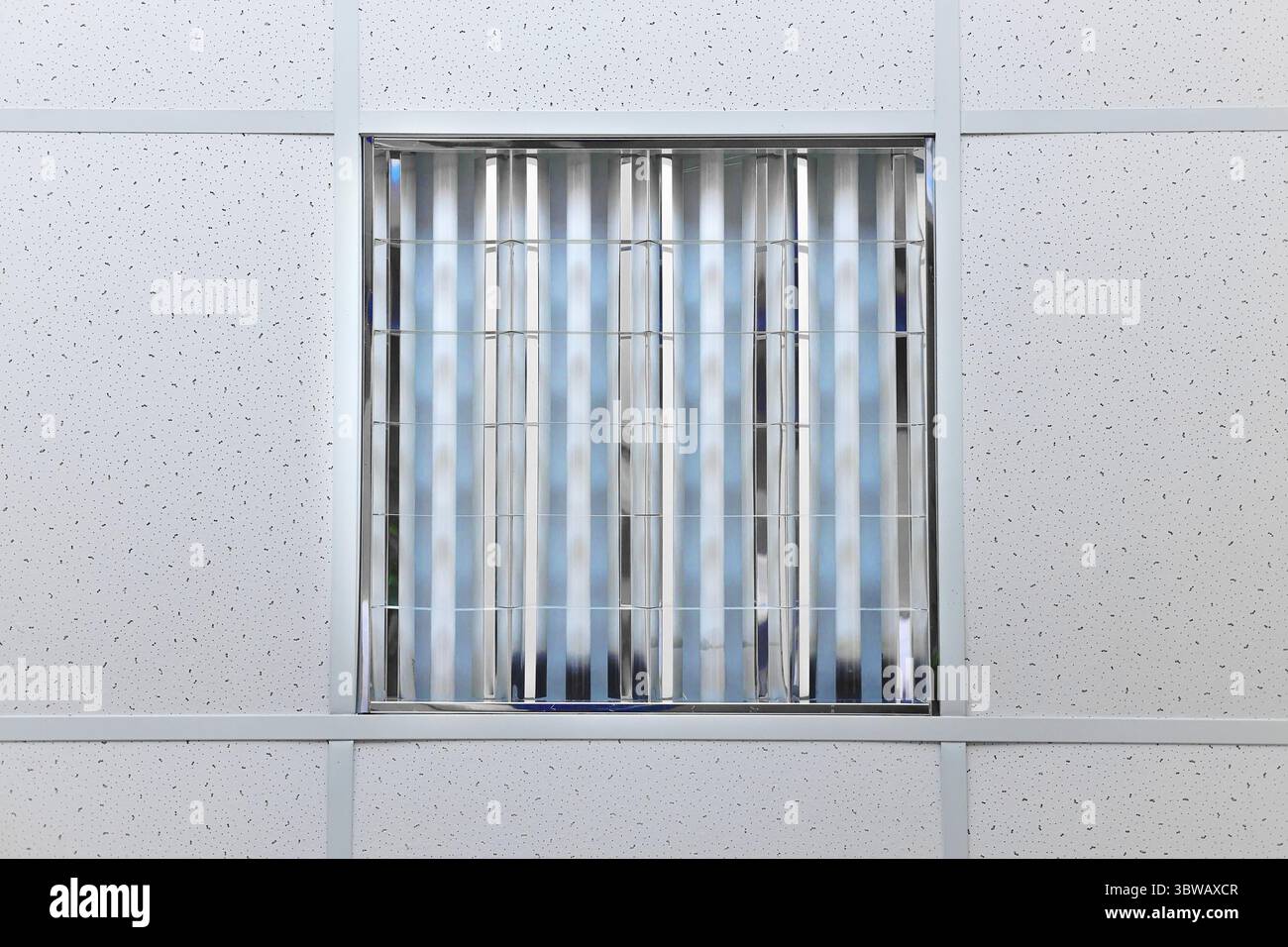 Office ceiling with square light fixture and fluorescent lights ...