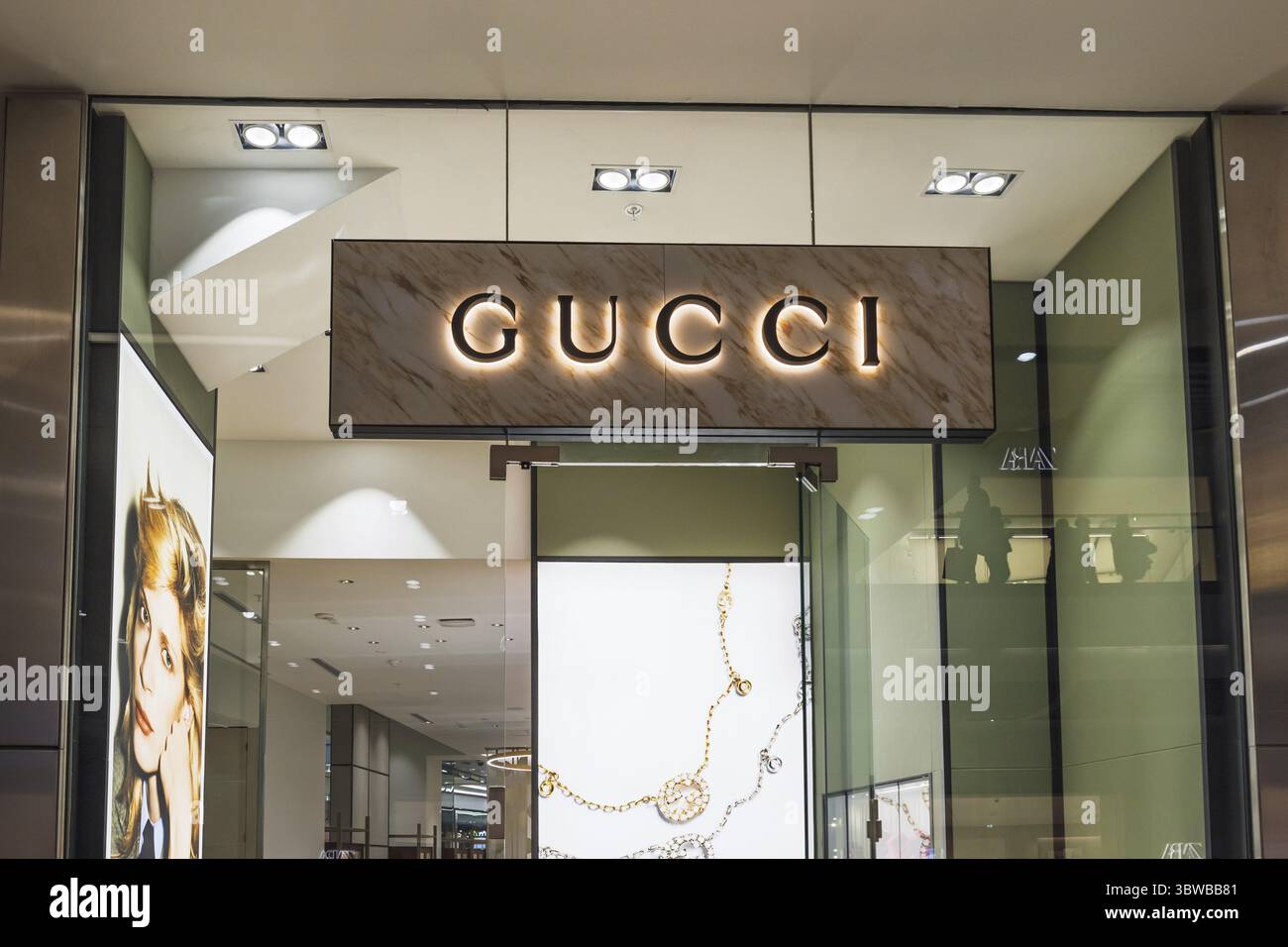 Gucci store entrance featuring illuminated signage and elegant glass ...