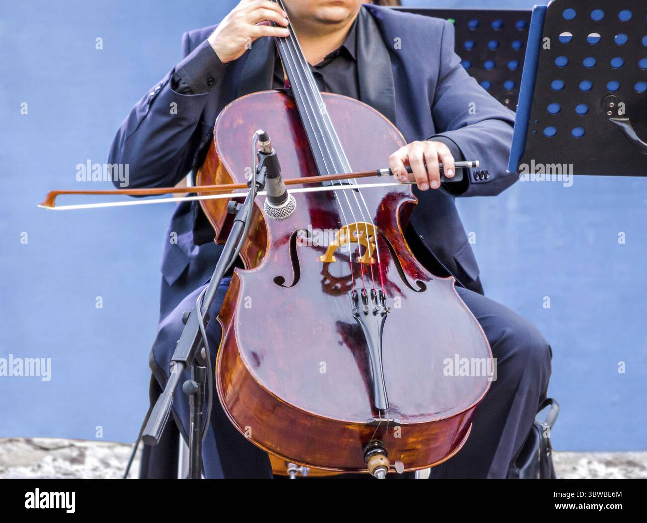 Musician in blue suit playing the cello Stock Photo - Alamy