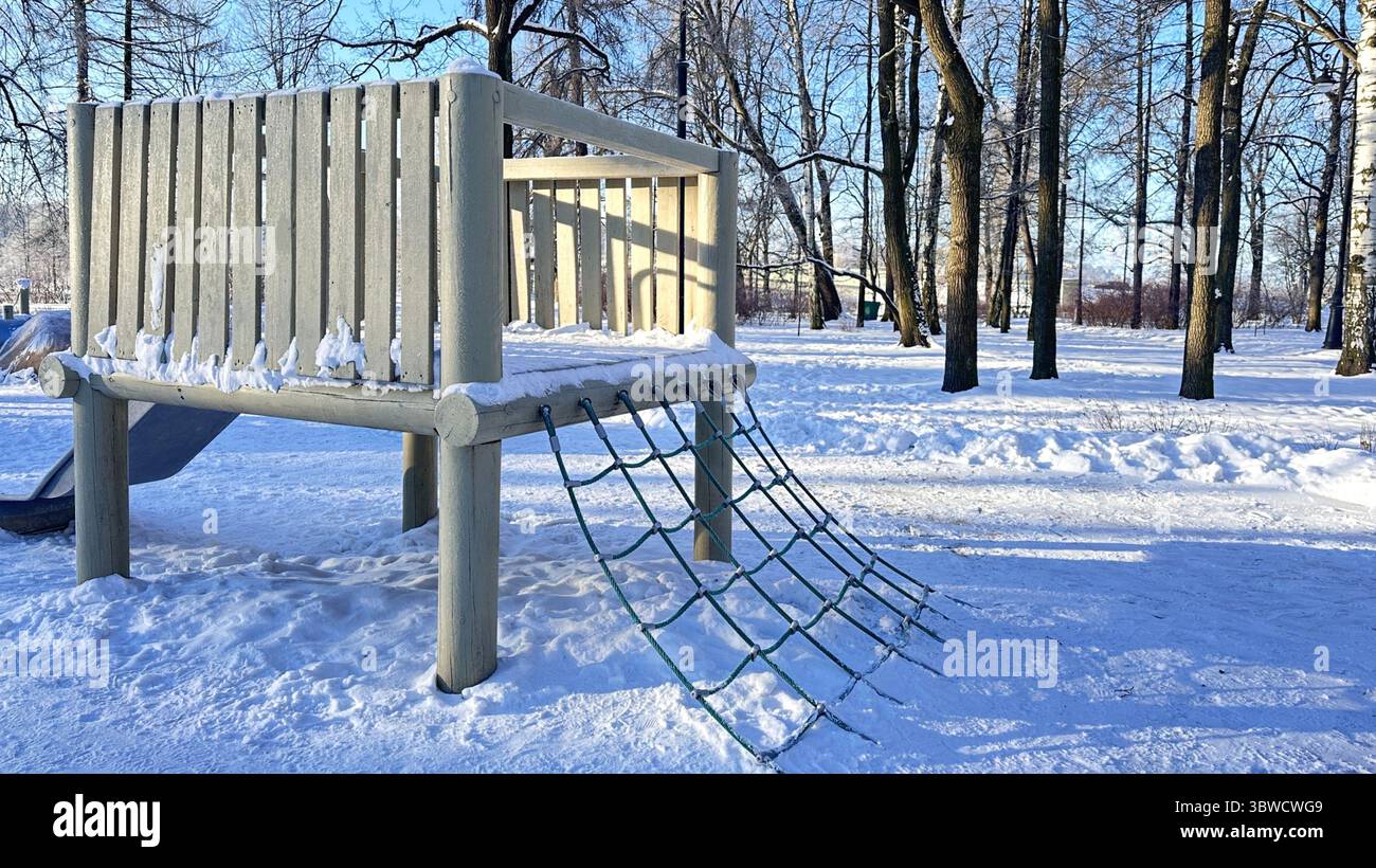Winter landscape with children's playground covered in snow. Wooden ...