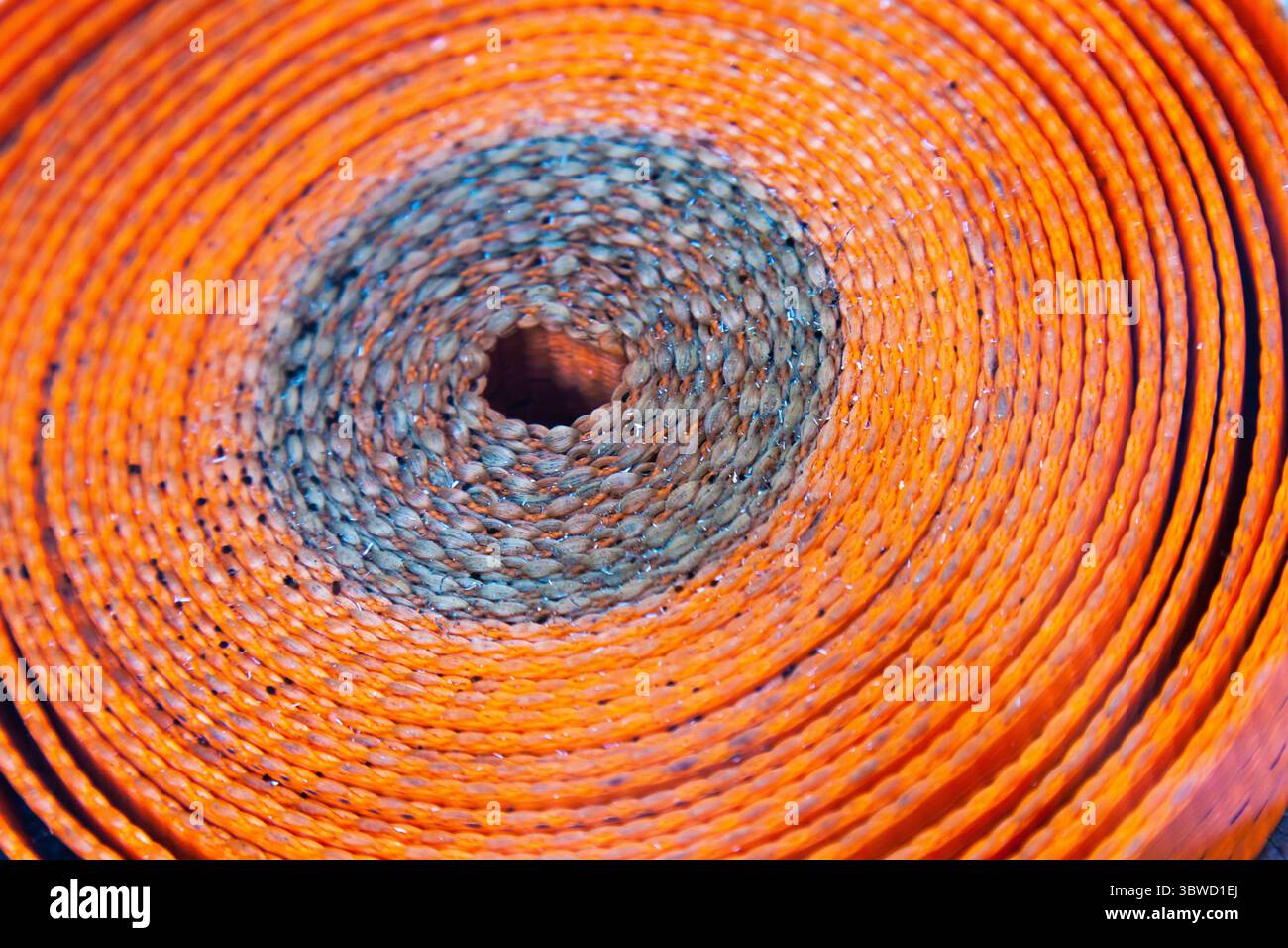 Twisted orange belt for securing cargo, close-up Stock Photo - Alamy