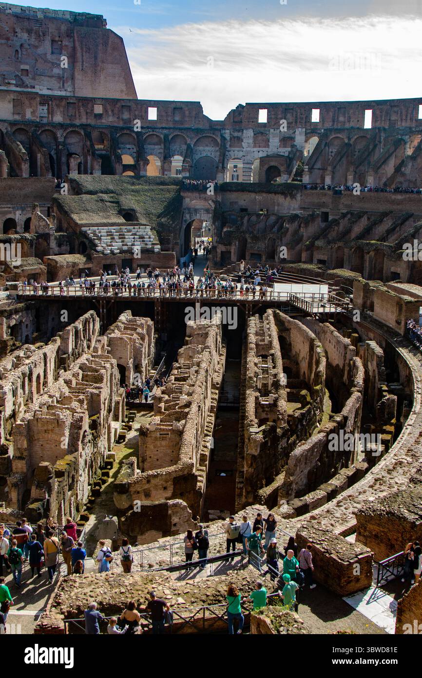 A crowd of people visiting the interior of the great Roman Colosseum ...