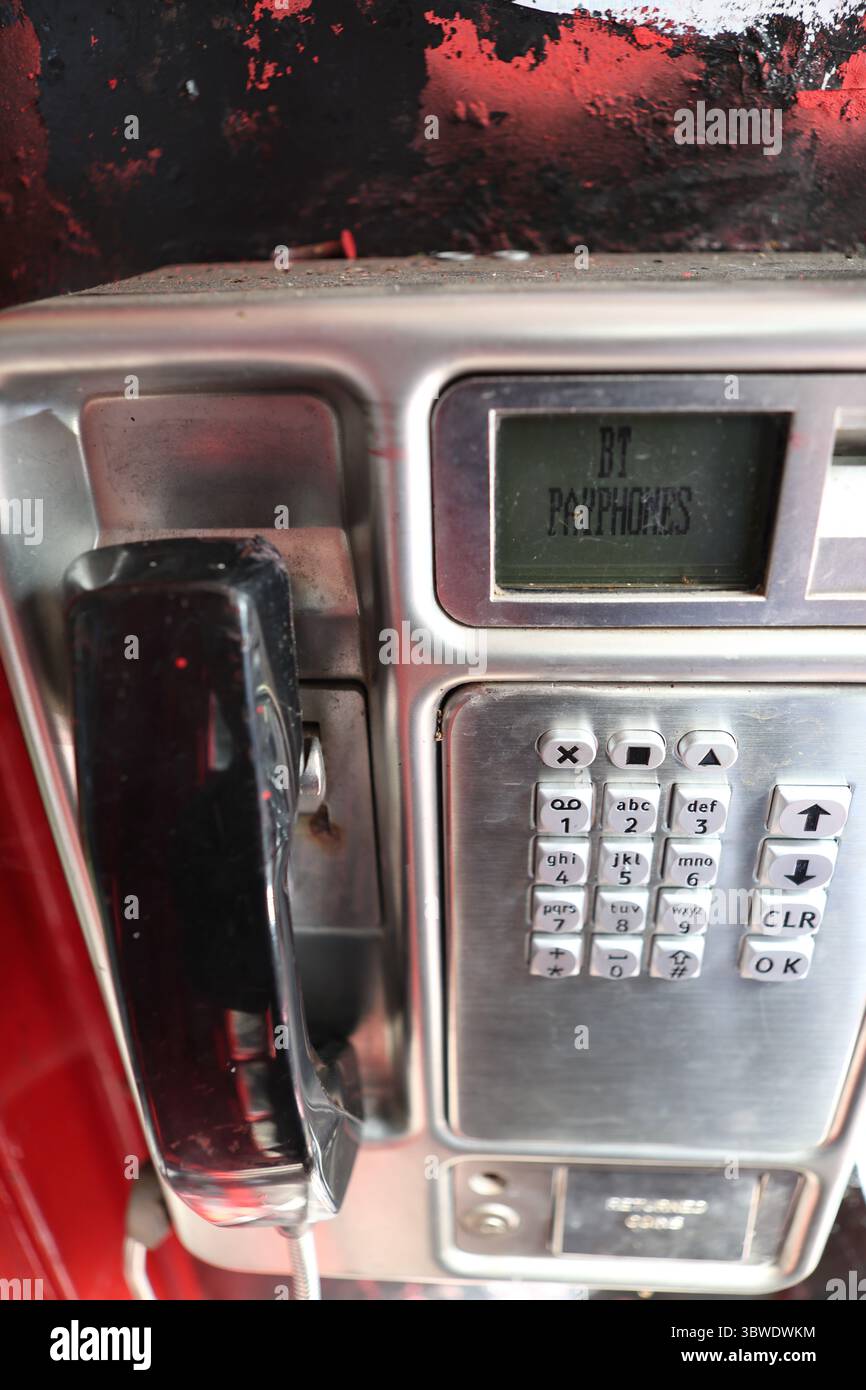 Traditional British red telephone box BT payphone close up of push ...