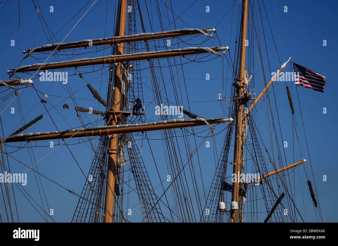 A member of the U.S. Coast Guard descends a mastcon the Barque Eagle ...