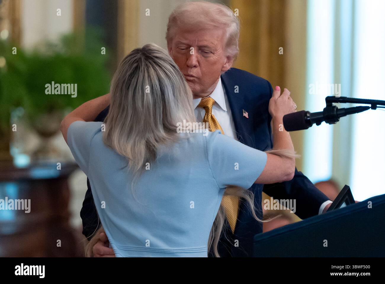 President Donald Trump kisses Anne Fundner after she spoke, during a ...