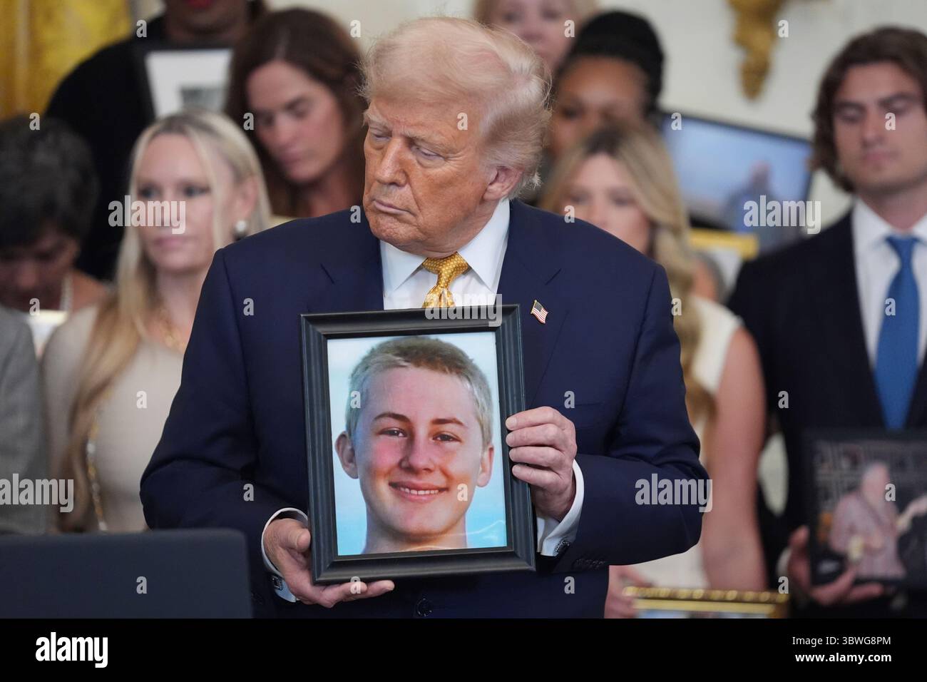 President Donald Trump holds a photo of Anne Funder's son, Weston ...