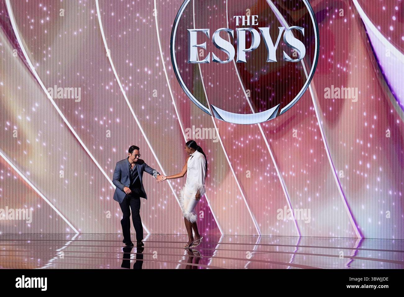 Anthony Ramos, left, walks on stage with Gabby Thomas at the ESPY ...
