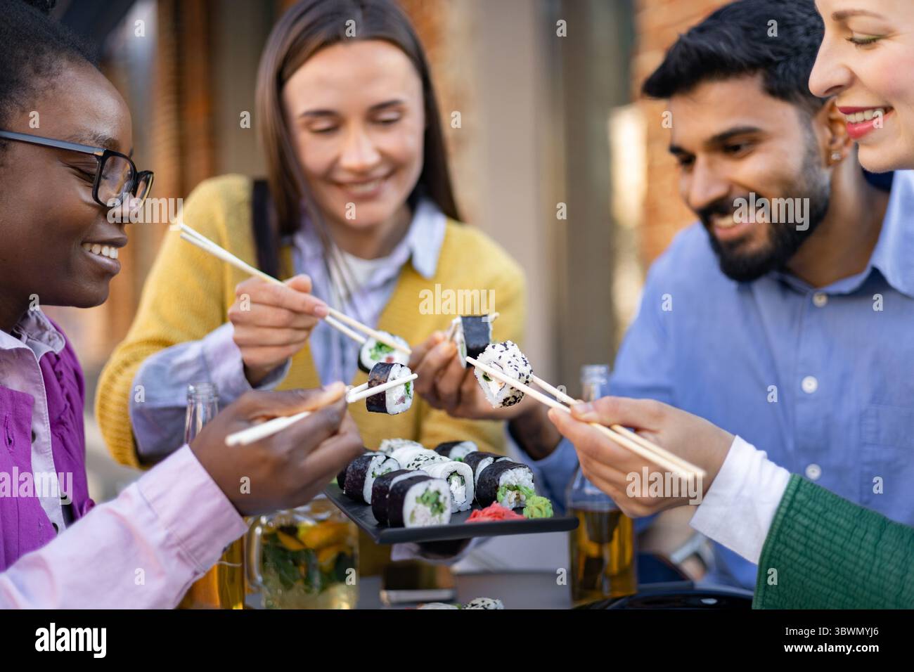 Diverse group friends enjoying sushi hi-res stock photography and ...