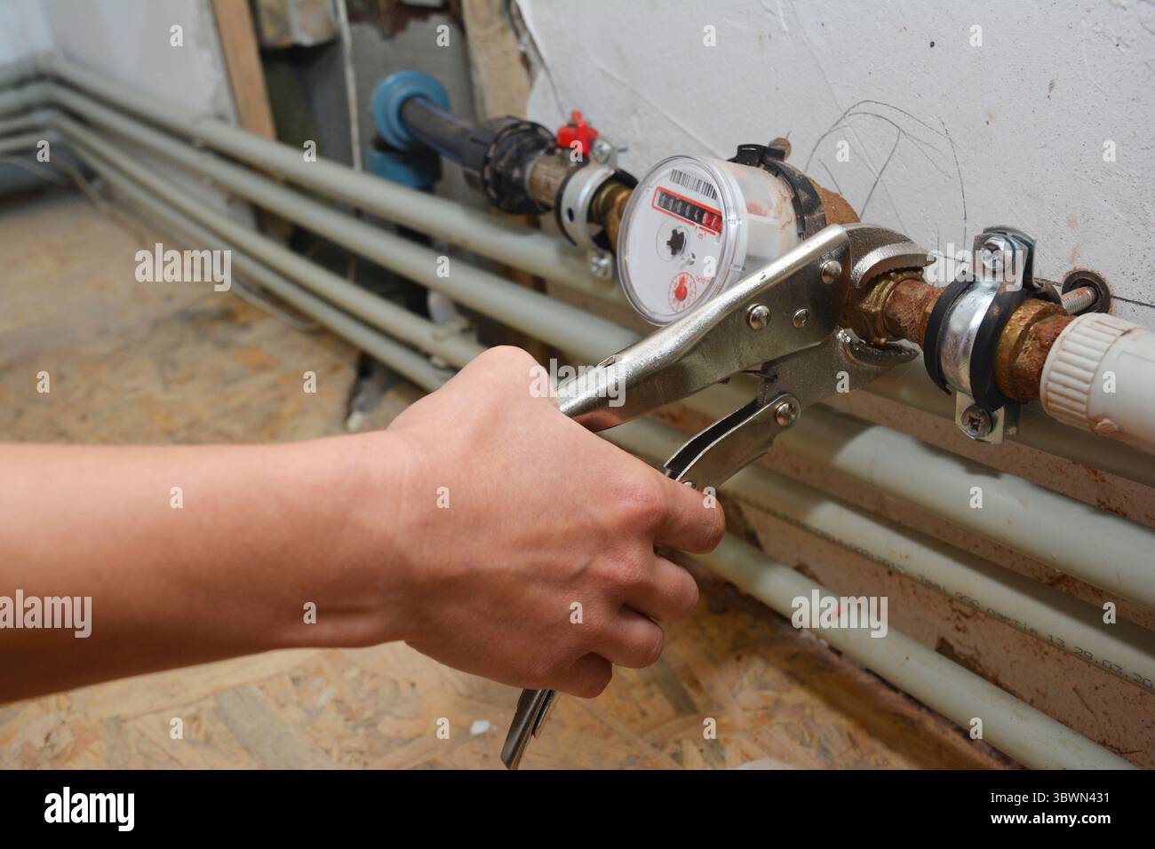 Plumber installing residential water meter on cold water pipeline Stock ...