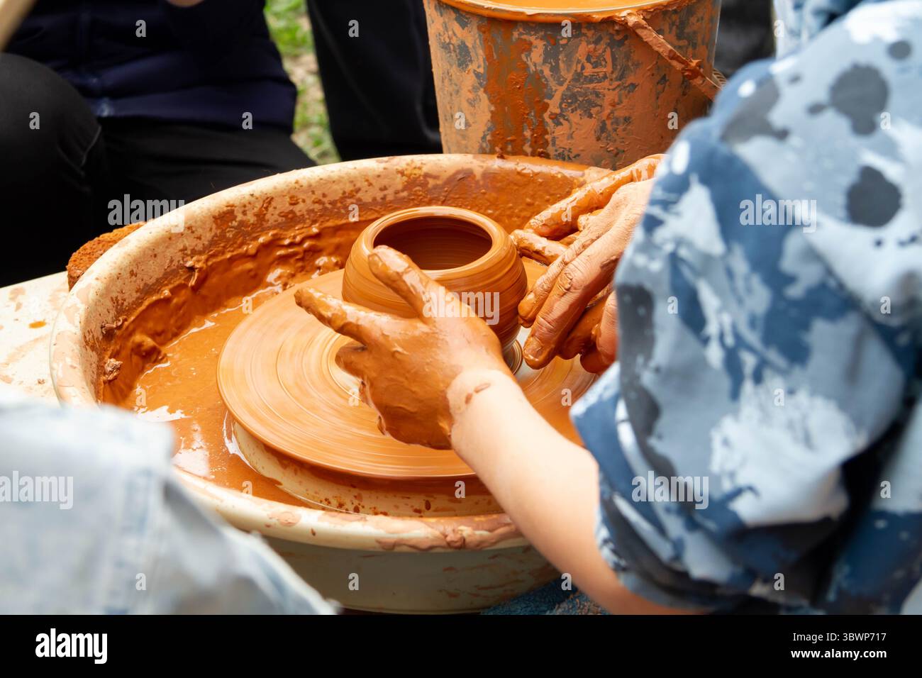 Pottery training. Rotating a clay pot on a machine. Hands knead clay ...
