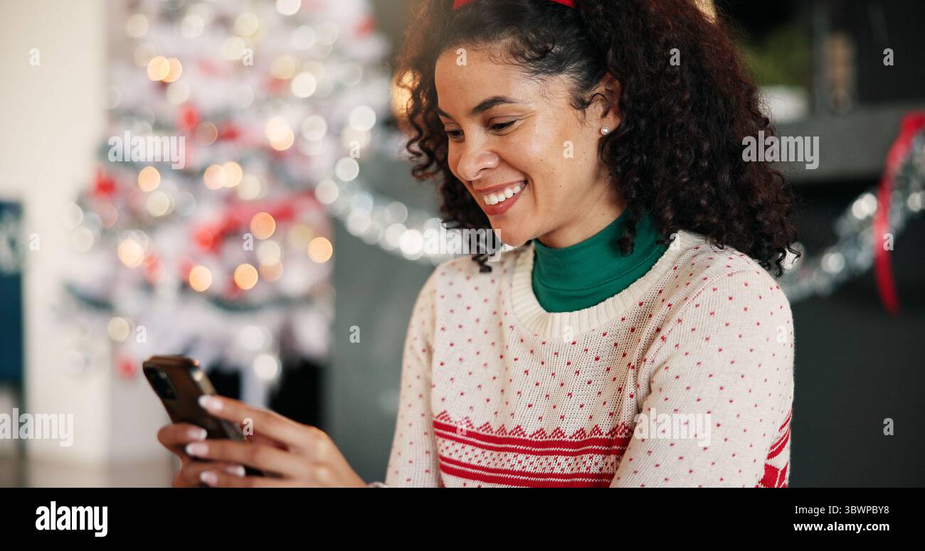 Christmas, woman and typing with phone in home for holiday text, season ...