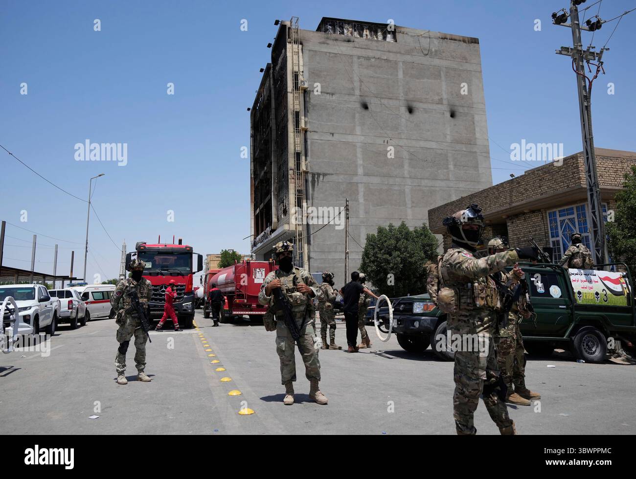 Iraqi Security forces gather in front of a burning hypermarket building ...