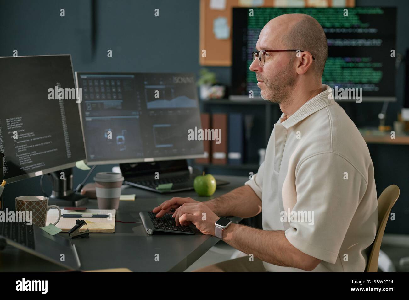 Middle aged Caucasian man working at computer desk using keyboard and ...