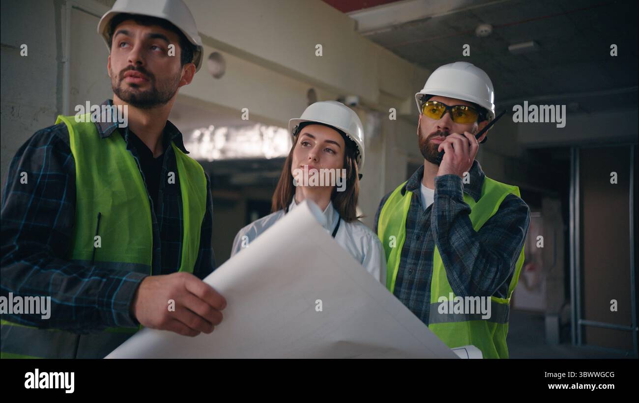 Caucasian team colleagues builders discuss blueprint building in ...