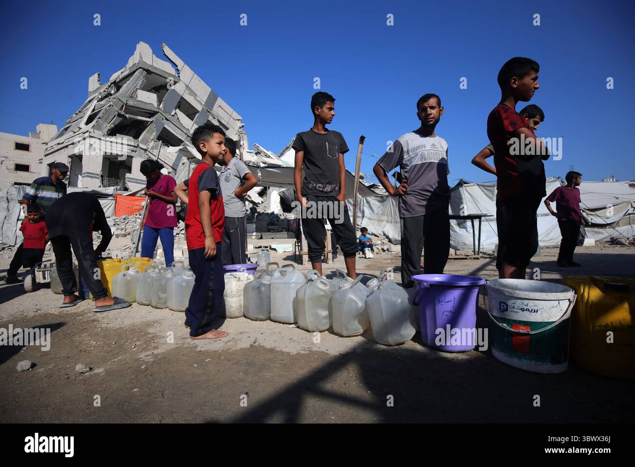 Palestinians try to meet their daily water needs by filling jerry cans ...