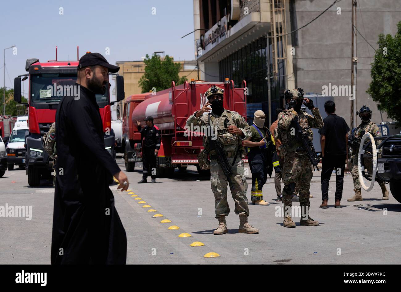 Iraqi Security forces gather in front of a burning hypermarket building ...